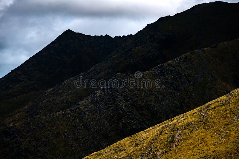 Multiple Dark Mountain Summits, Layered and Steep, with a Stormy Sky ...