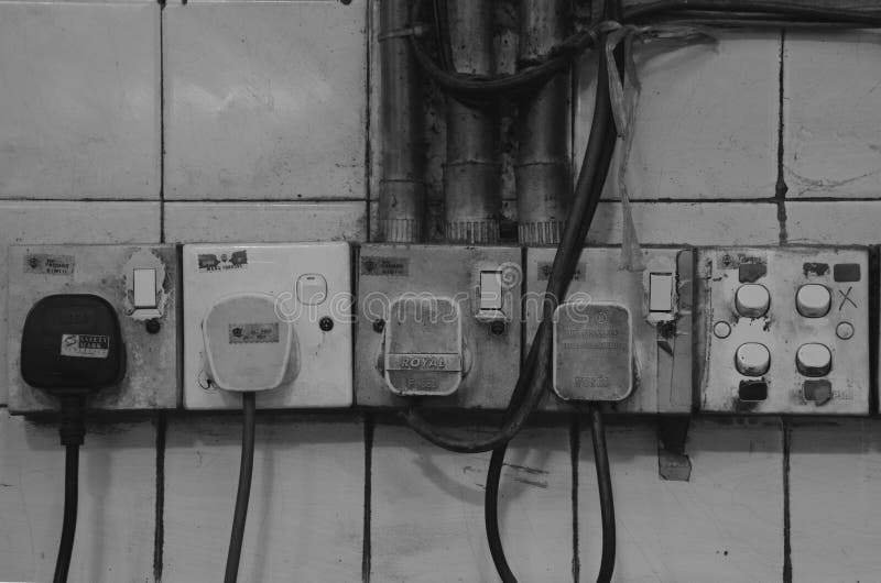 Multiple Electrical Outlets and Switches Mounted on a Tiled Wall, with ...