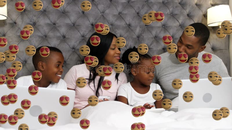 Multiple Face Emojis Floating Against Family Using Electronic Devices ...