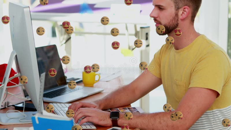 Multiple Face Emojis Floating Against Man Using Computer at Office ...