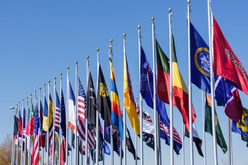 Multiple International Flags Waving on Tall Flagpoles Against a Clear ...