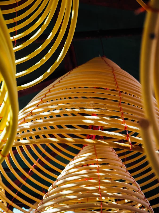 Multiple Large Yellow Incense Coils Hanging in Stacks from the Ceiling ...