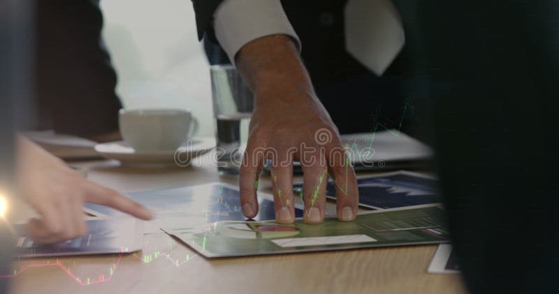 Multiple People Standing Around Table, Examining Documents and Charts ...