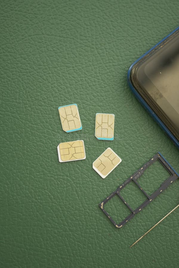 Multiple SIM Cards and a Smartphone on a Green Surface Stock Photo ...