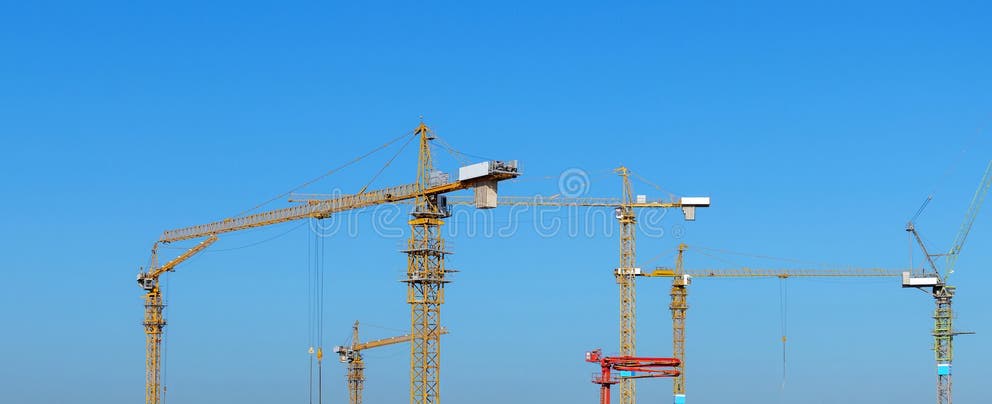 Multiple Tower Cranes at a Large Construction Site Under a Clear Blue ...