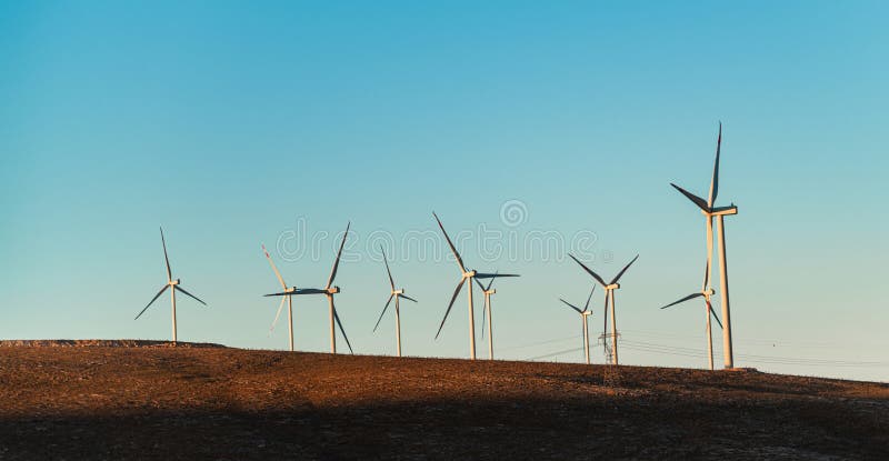 Multiple Wind Turbines Standing on a Hill at Sunrise and Generating ...