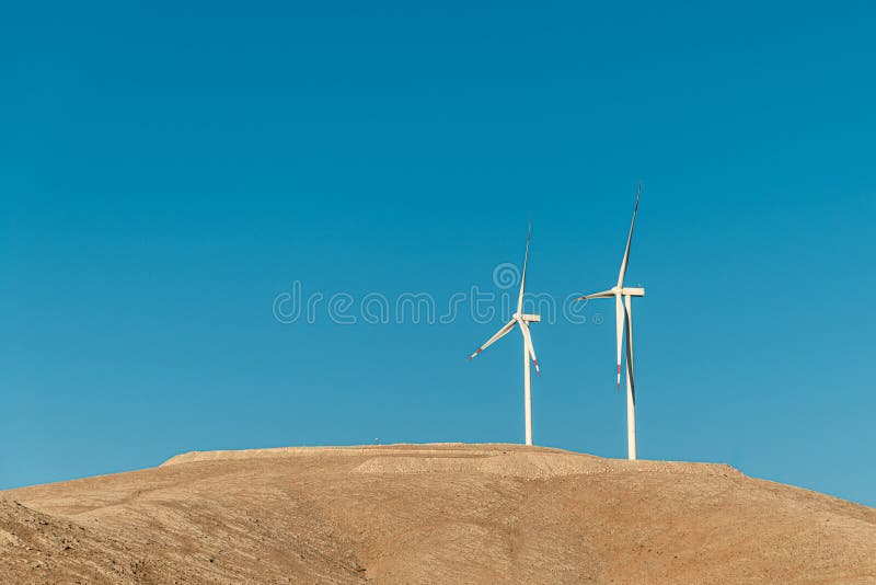 Multiple Wind Turbines Standing on a Hill at Sunrise and Generating ...