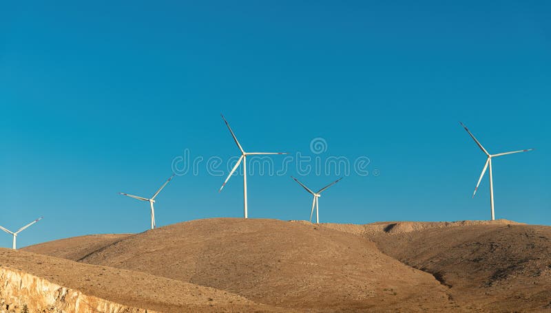 Multiple Wind Turbines Standing on a Hill at Sunrise and Generating ...