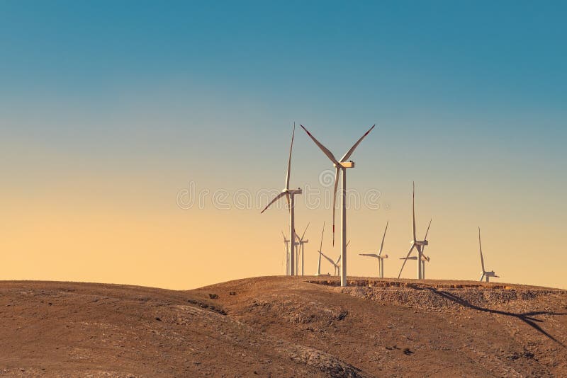 Multiple Wind Turbines Standing on a Hill at Sunset and Generating ...