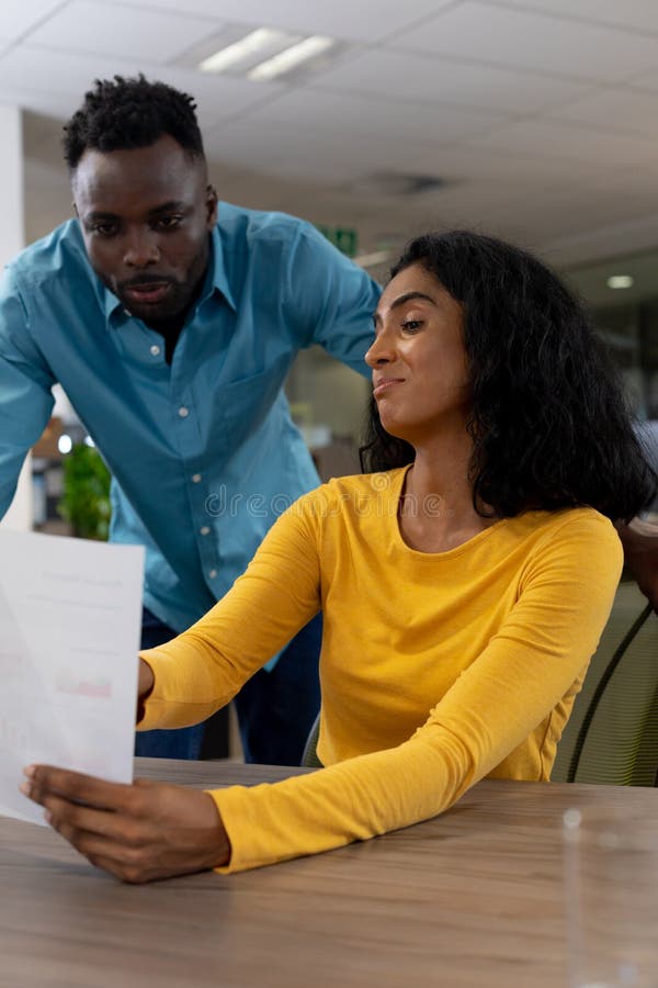 Multiracial Business Colleagues Discussing Over Document while Planning ...