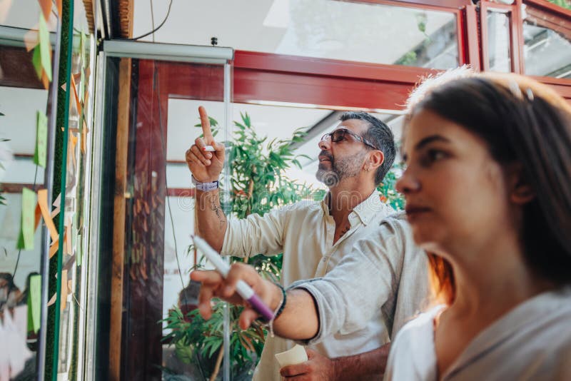 Multiracial Business Team Collaborating on Glass Wall, Sharing Ideas ...