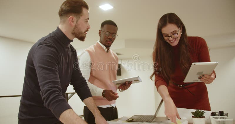 A Multiracial Business Team Analyzes Documents Outside a Modern Office ... A Multiracial Business Team Analyzes Documents Outside a Modern Office ...