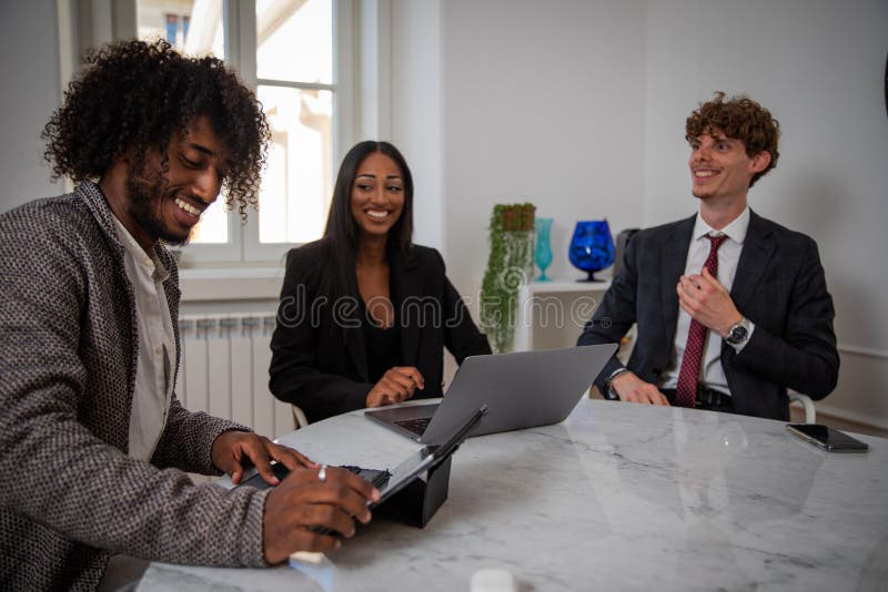 Multiracial Colleagues Sitting Around the Table in the Office Discuss ...
