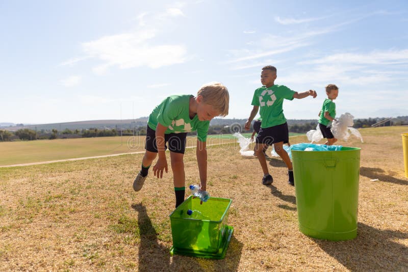 Multiracial Elementary Schoolboys Putting Plastic Garbage in Garbage ...