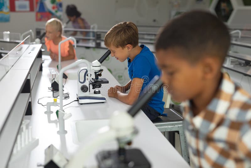 Multiracial Elementary Students Looking in Microscope during Science ...