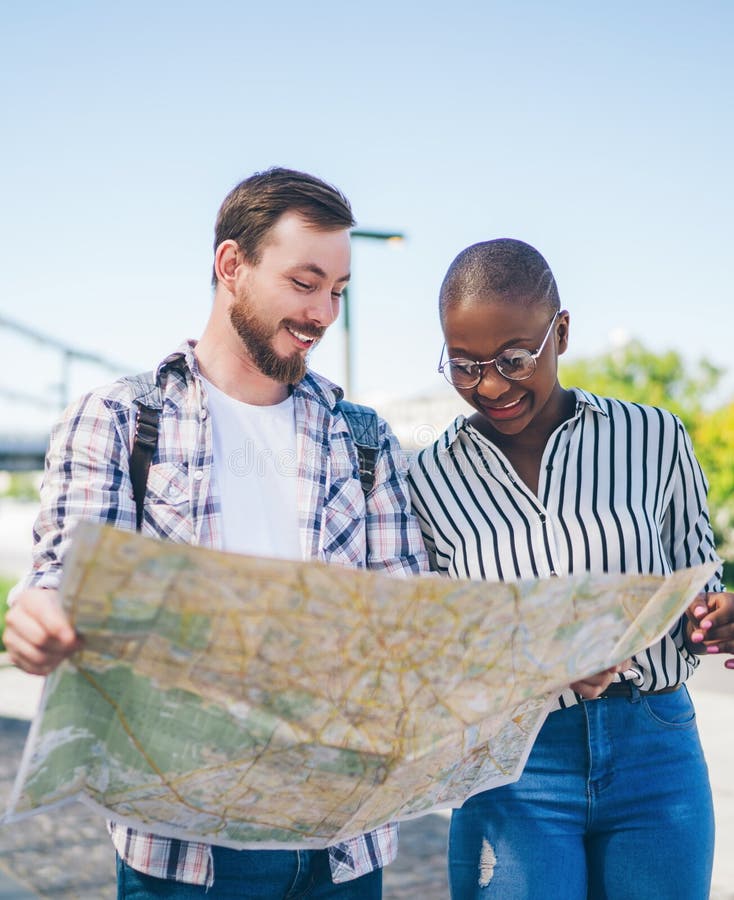 Multiracial Friends Smiling and Watching Open Map on Empty Road Stock ...