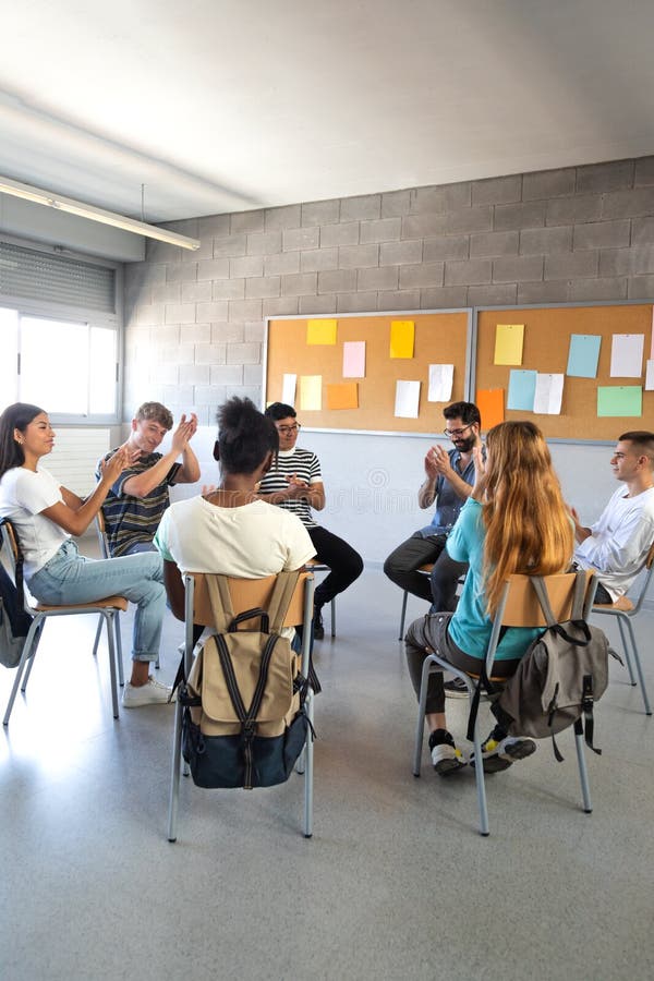Multiracial Group of High School Students Sitting in a Circle Clapping ...