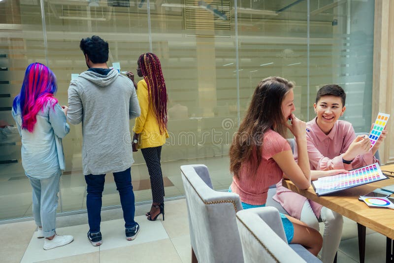 Multiracial Group Standing Near Wall and Put Sticky Sticker on Glass ...