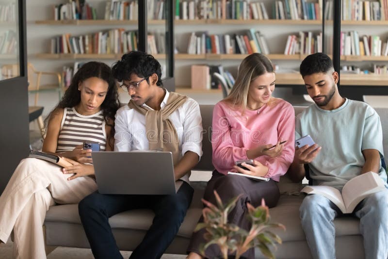 Multiracial Group of Students Studying in Library Talking Using Gadgets ...