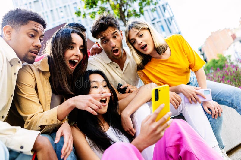 Multiracial Group of Young Friends Looking Surprised at Mobile Phone ...