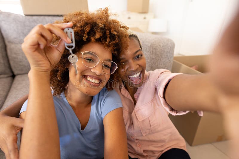 Multiracial Lesbian Couple Screaming And Smiling While Showing New