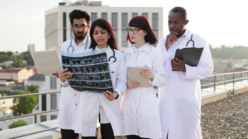 Multiracial Medical Workers Using Gadgets while Examining Results of X ...