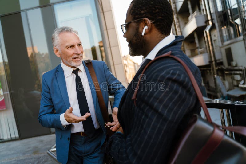 Multiracial Men Talking and Gesturing while Standing by Building Stock ...