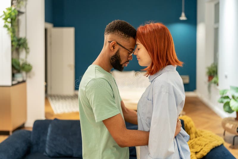 Multiracial Millennial Couple In Love Hugging Embracing At Home Making