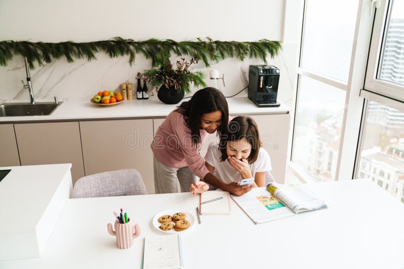 White Preteen Girl Eating Cookie while Doing Homework Stock Photo ...