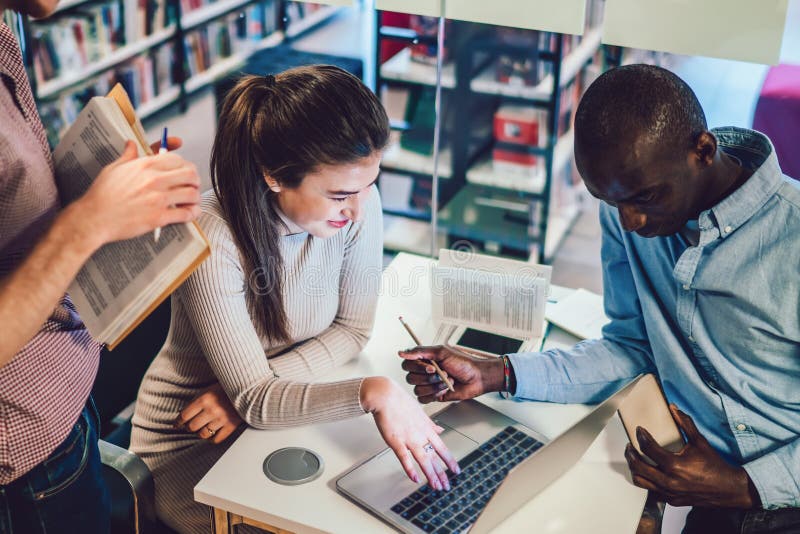 Multiracial Students Cheerfully Discussing Project in Library Stock ...