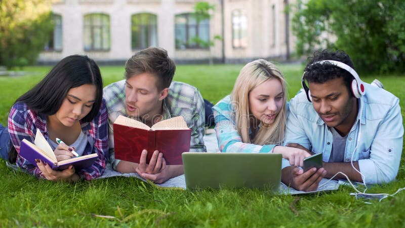 Multiracial Students Preparing for Lessons, Talking with Each Other ...