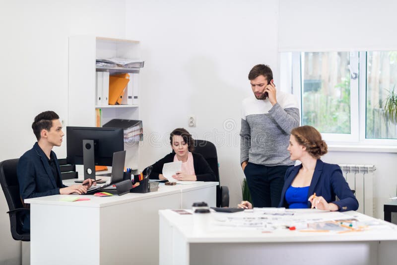 A Multiracial Team Busy Working on Computers, Communicating, Coo Stock ...
