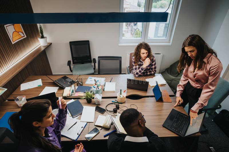 Multiracial Team Discussing Project in Lively Office Environment Stock ...