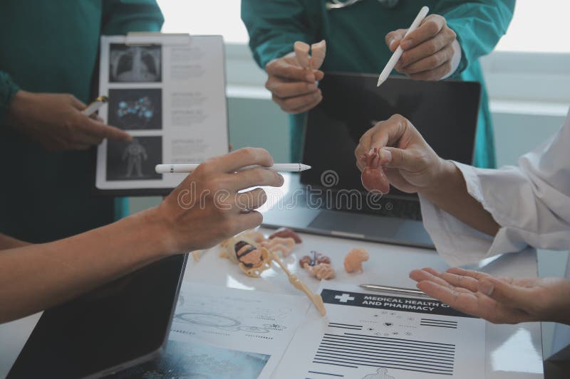 Multiracial Team of Doctors Discussing a Patient Standing Grouped in ...