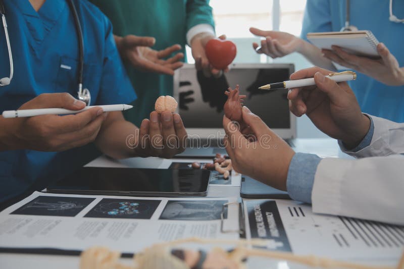 Multiracial Team of Doctors Discussing a Patient Standing Grouped in ...