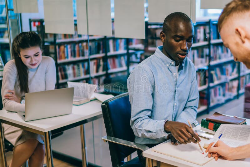 Multiracial Team of Students Cooperating in Library Stock Photo - Image ...