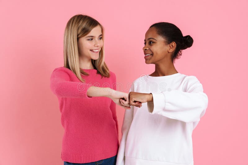 Multiracial Two Girls Wearing Sweaters Smiling and Fists Bumping Stock ... Multiracial Two Girls Wearing Sweaters Smiling and Fists Bumping Stock ...