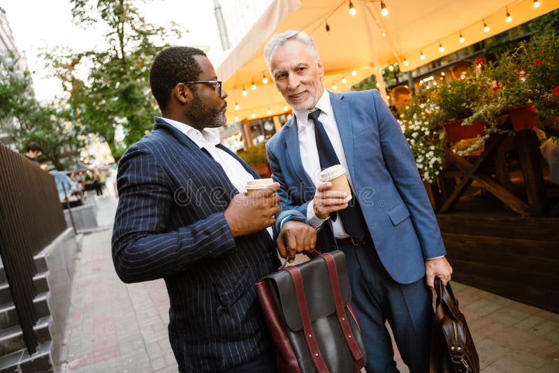Multiracial Two Men Wearing Suits Talking while Drinking Coffee Stock ...