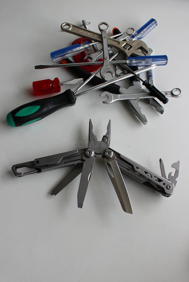 Multitool and a Stack of Variety Hand Tools on Different Sides of a ...