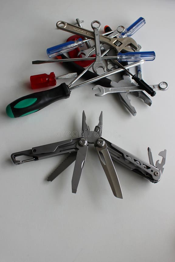 Multitool and a Stack of Variety Hand Tools on Different Sides of a ...