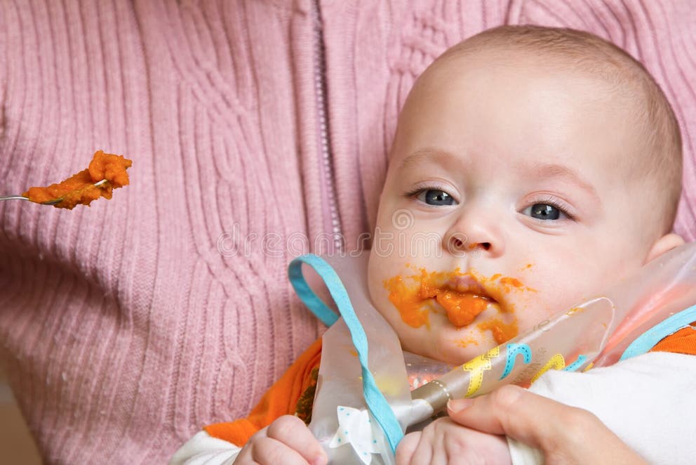 Mum spoon-feeds the child stock image. Image of motherhood - 26998935