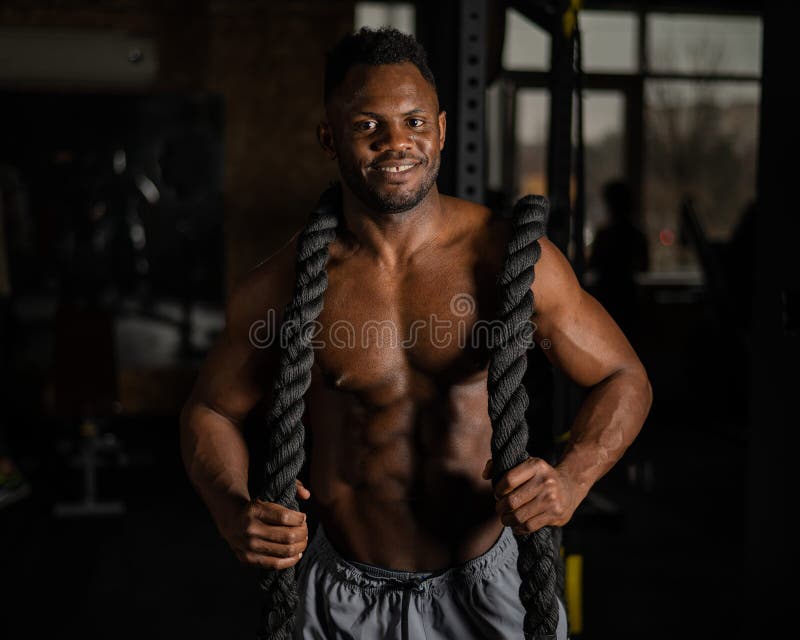 Muscular African American Man Posing with Rope in Gym. Stock Photo ...