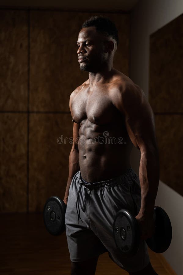 Muscular Dark-skinned Man Doing an Exercise with Dumbbells. Stock Photo ...