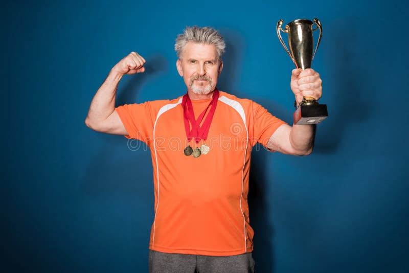 Muscular Elderly Man Holding Trophy and Showing Biceps Stock Photo ...