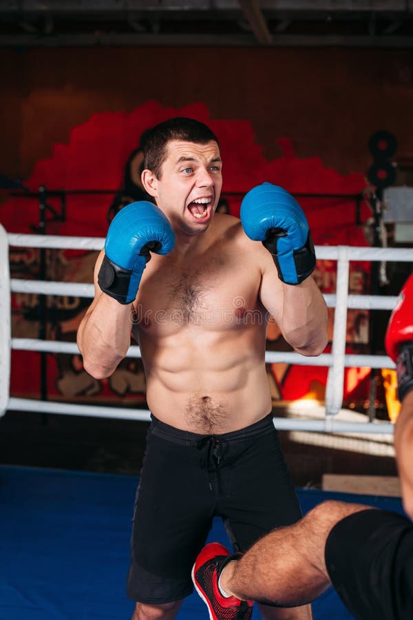 Muscular Fighter Practicing with Punching Bag Against White Brick Wall ...