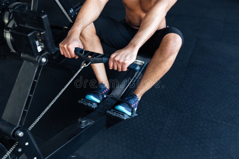 Muscular Fitness Man Using Rowing Machine in the Gym Stock Photo ...