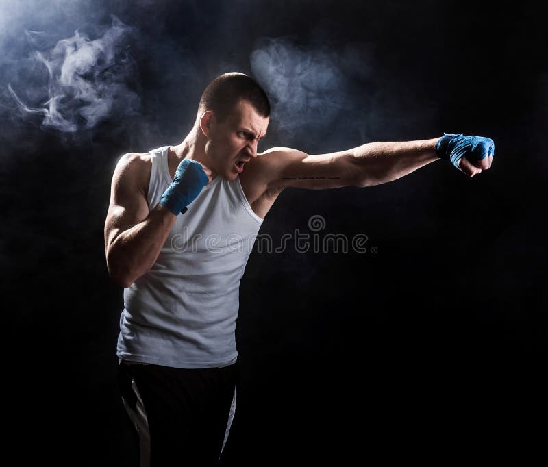 Muscular Kickbox or Muay Thai Fighter Punching in Smoke Stock Image ...
