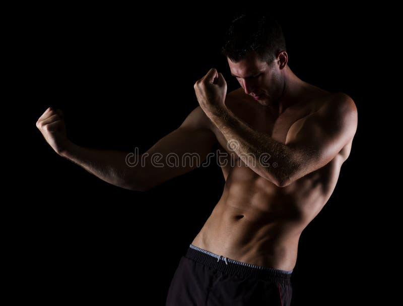 Muscular Man in Attack Pose on Black Stock Photo - Image of pose ...