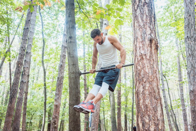 Man Doing Gymnastics on High Bar in the Woods Stock Photo - Image of ...