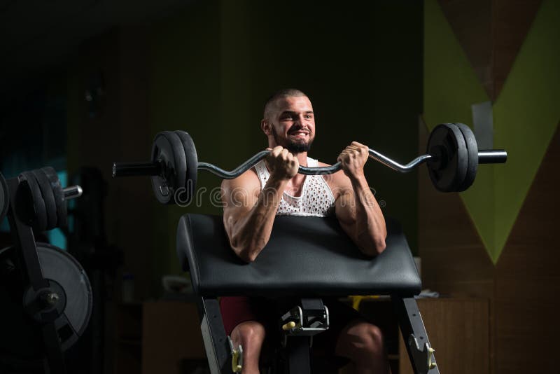 Man in the Gym Exercising Biceps with Barbell Stock Photo - Image of ...